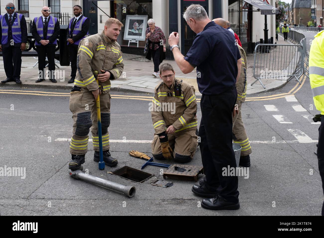 Couvercle de trou d'homme ouvert. Les pompiers discutent de la façon de ...