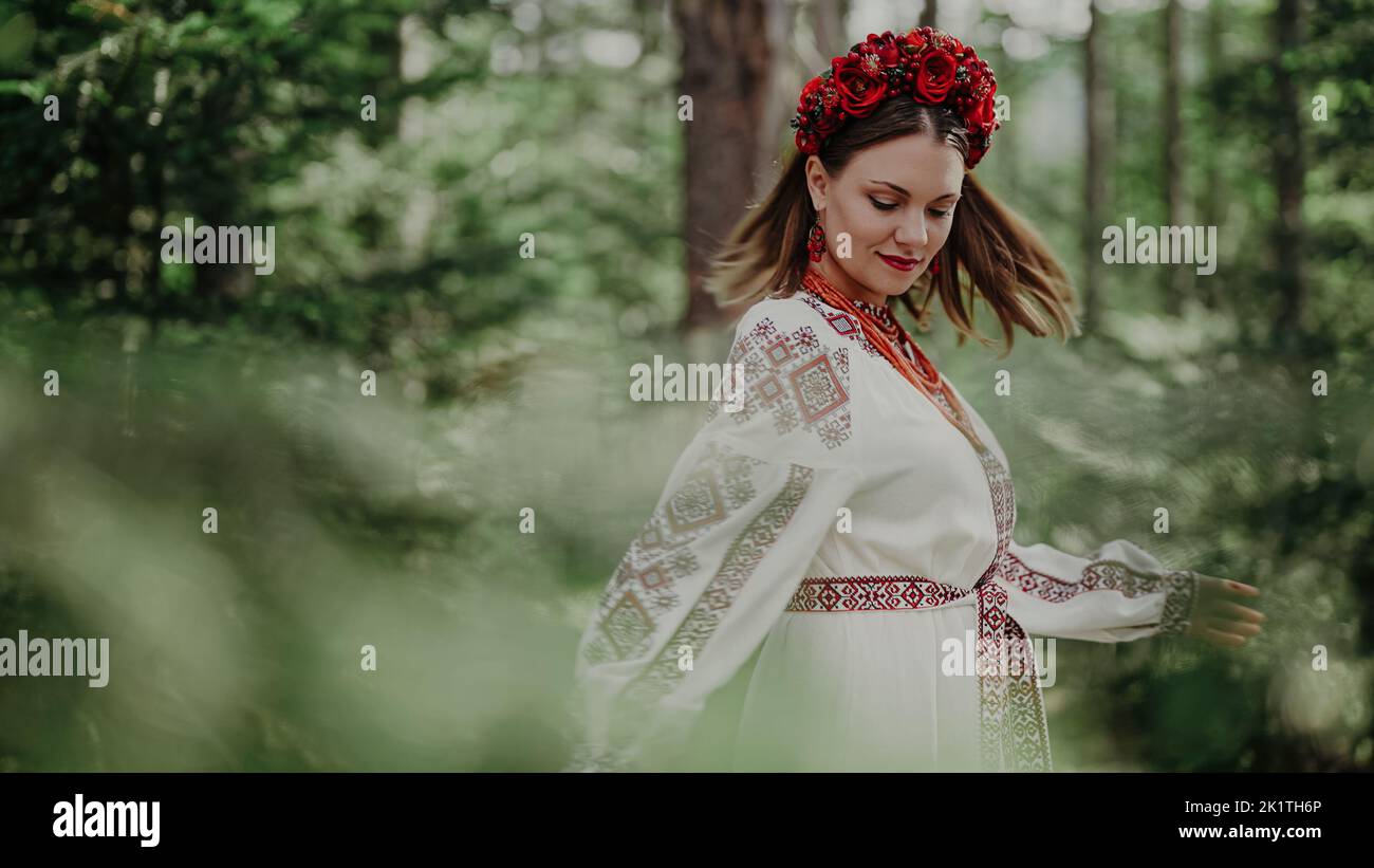 Belle femme ukrainienne dansant dans la forêt de sapins, Carpathian montagnes nature. Fille en ...