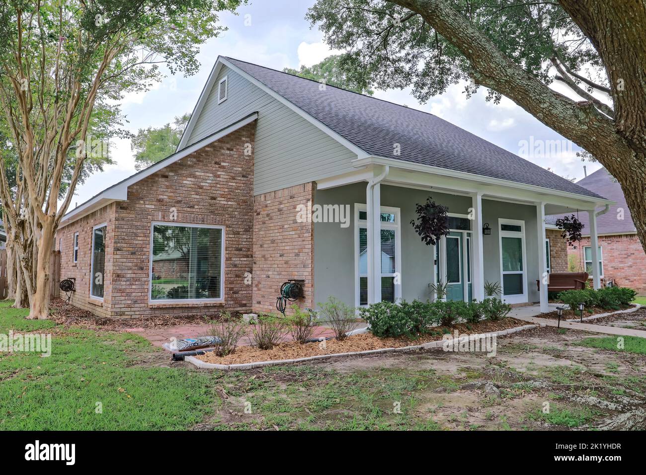 Une vue latérale et avant inclinée d'une maison acadienne rénovée avec ...