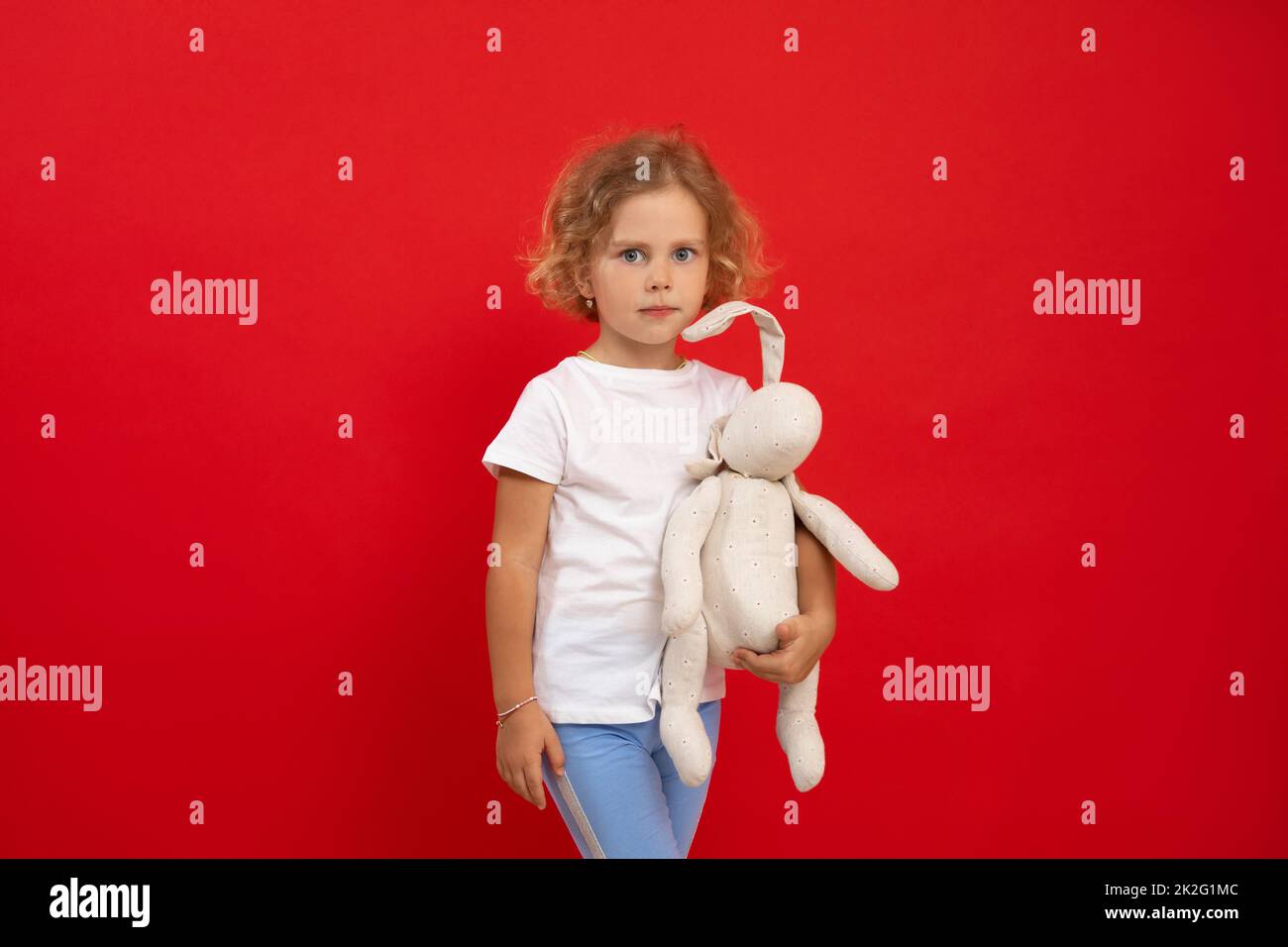 Charmante petite fille tient en main jouet bourré préféré sur fond ...