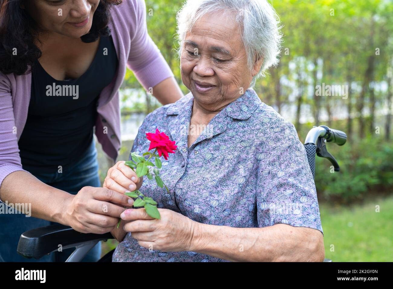La fille du soignant se câlin et aide la vieille femme asiatique âgée ...