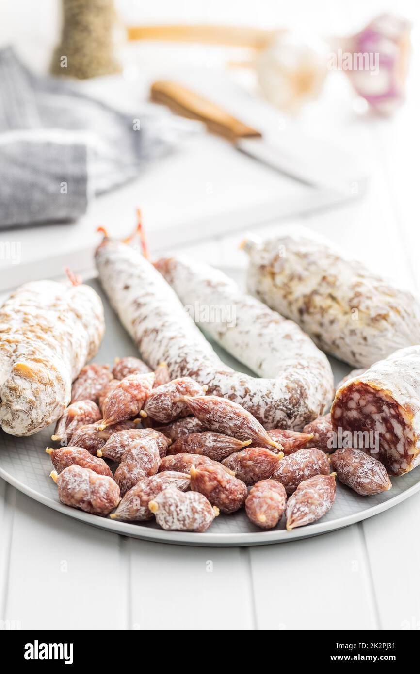 Saucisse traditionnelle avec moule blanc. Salami de porc en tranches séchées sur l'assiette ...