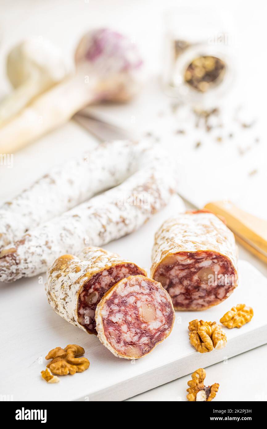 Saucisse traditionnelle avec moule blanc. Salami de porc en tranches séchées sur la planche à ...