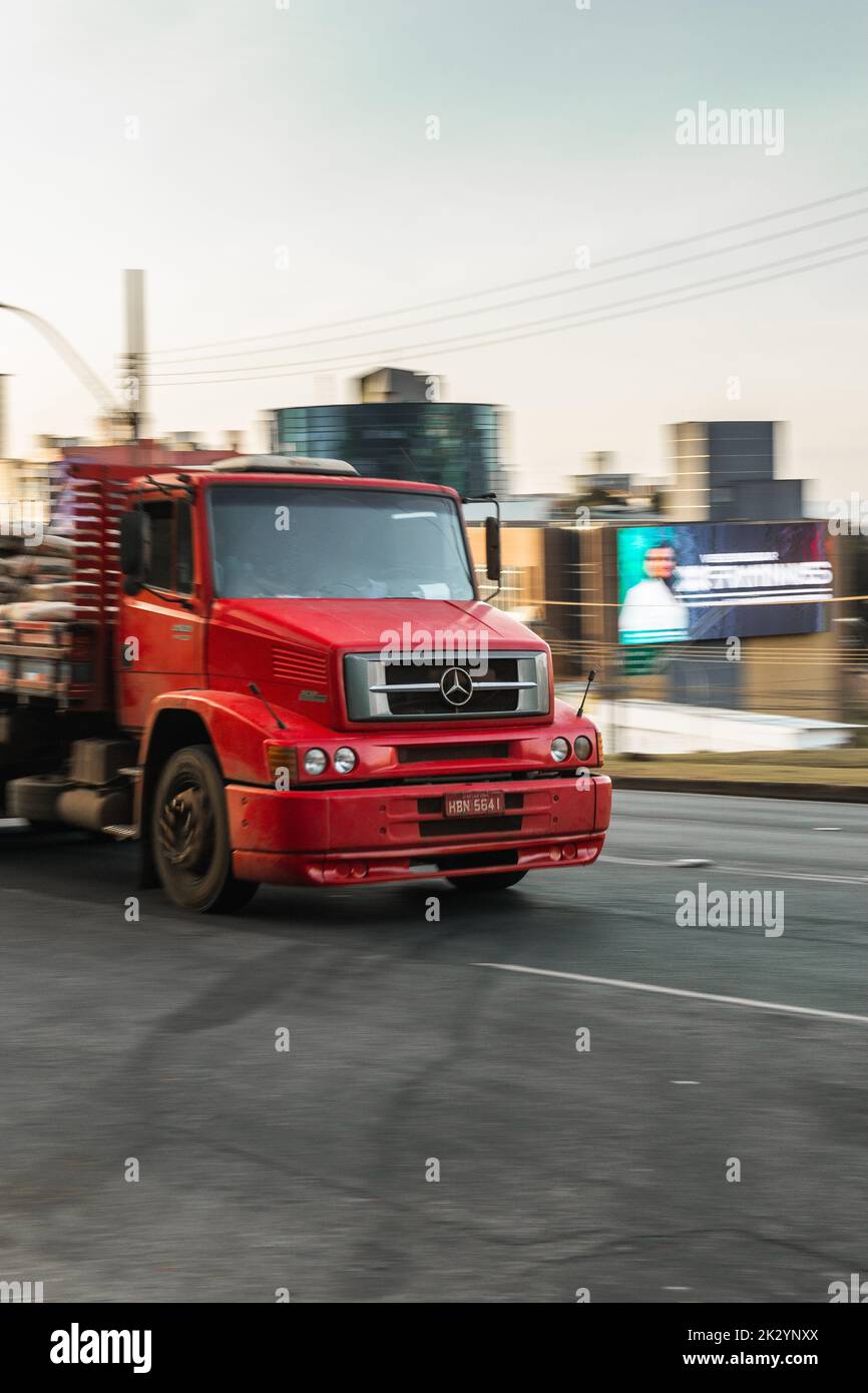 Photo verticale d'un vieux camion Mercedes Benz rouge qui roule sur la ...