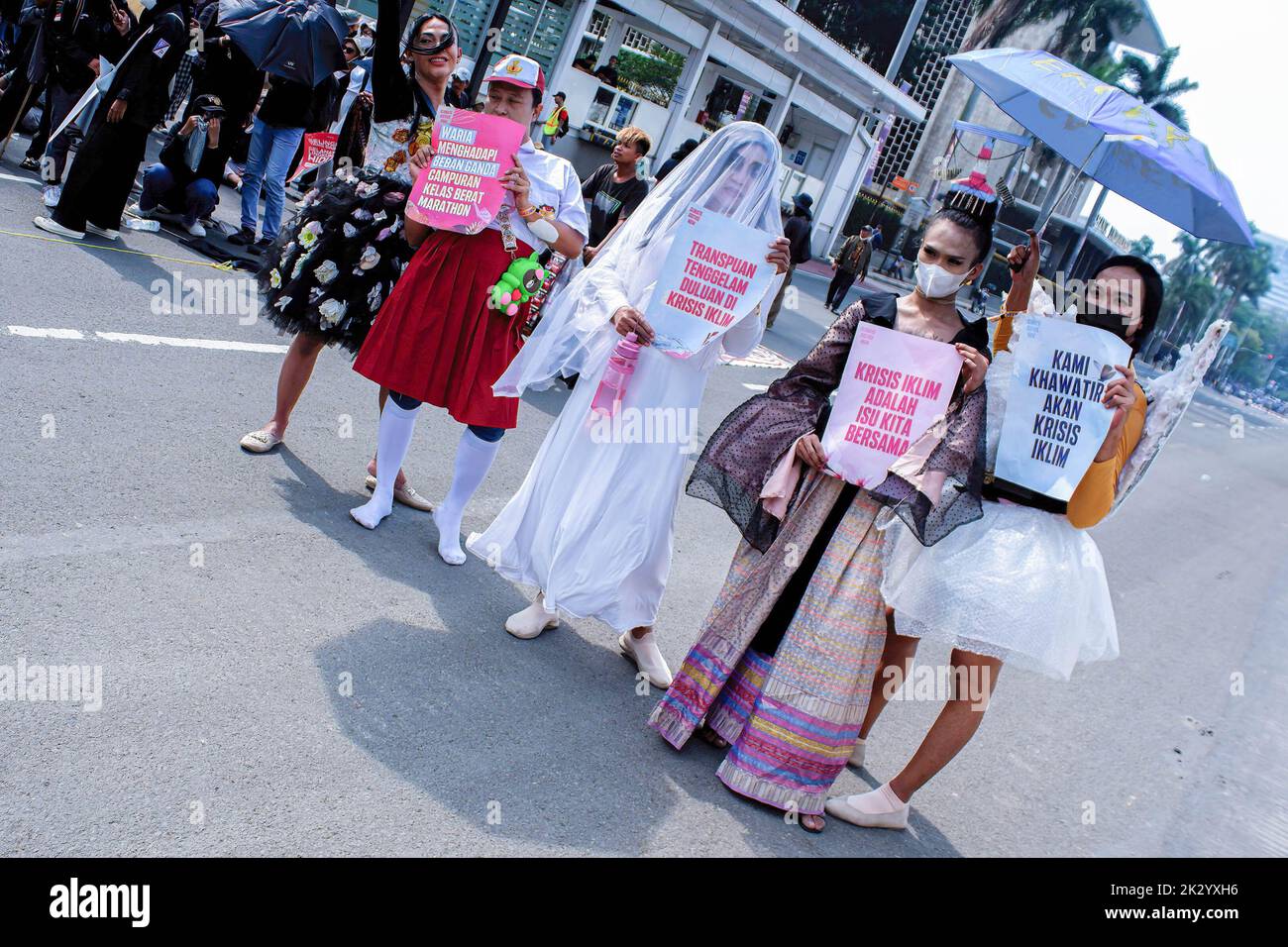 Les activistes en costumes tiennent des écriteaux exprimant leur ...
