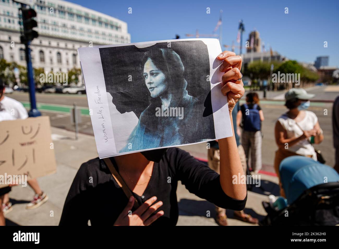 Un manifestant tient un portrait de Mahsa Amini pendant la ...