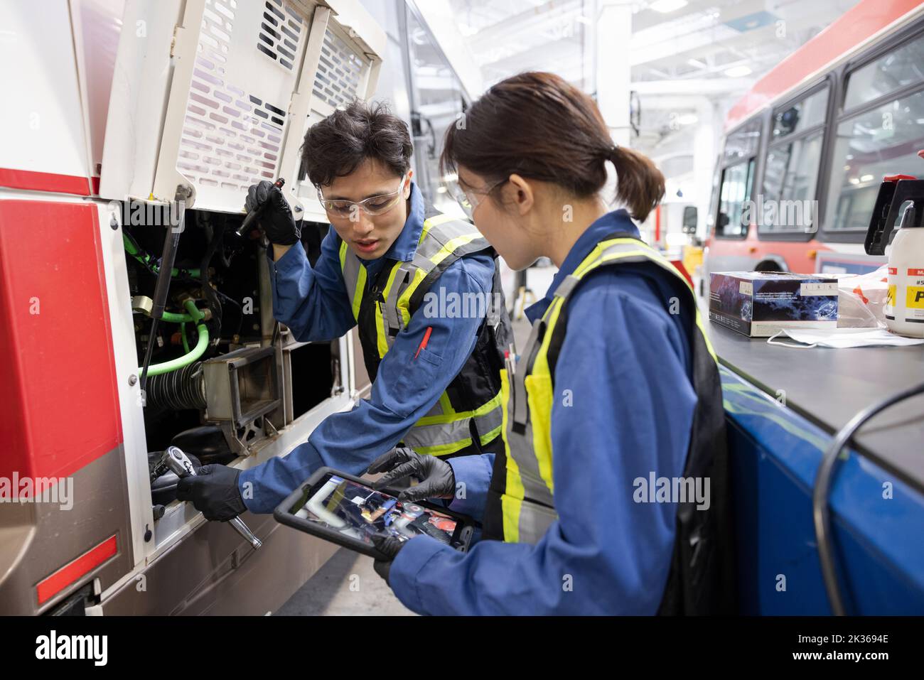 Mécanique avec tablette numérique inspectant le bus dans l'installation ...