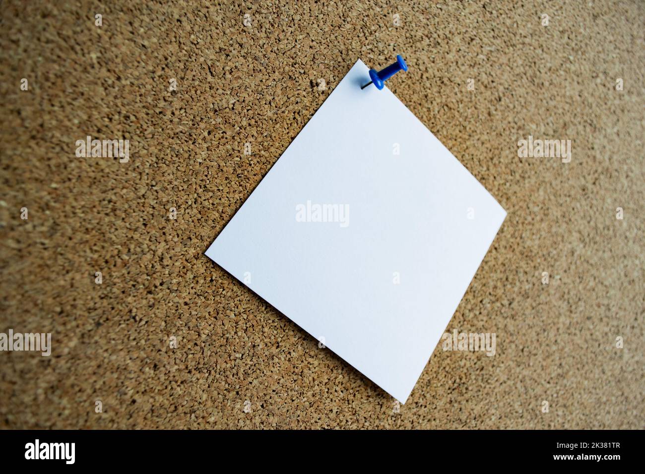 Gros plan d'une note en papier blanc sur un panneau en liège, attaché ...