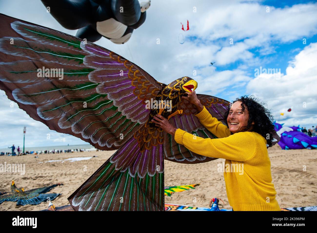 Une femme pose avec une de sa main fait des cerfs-volants en forme d ...