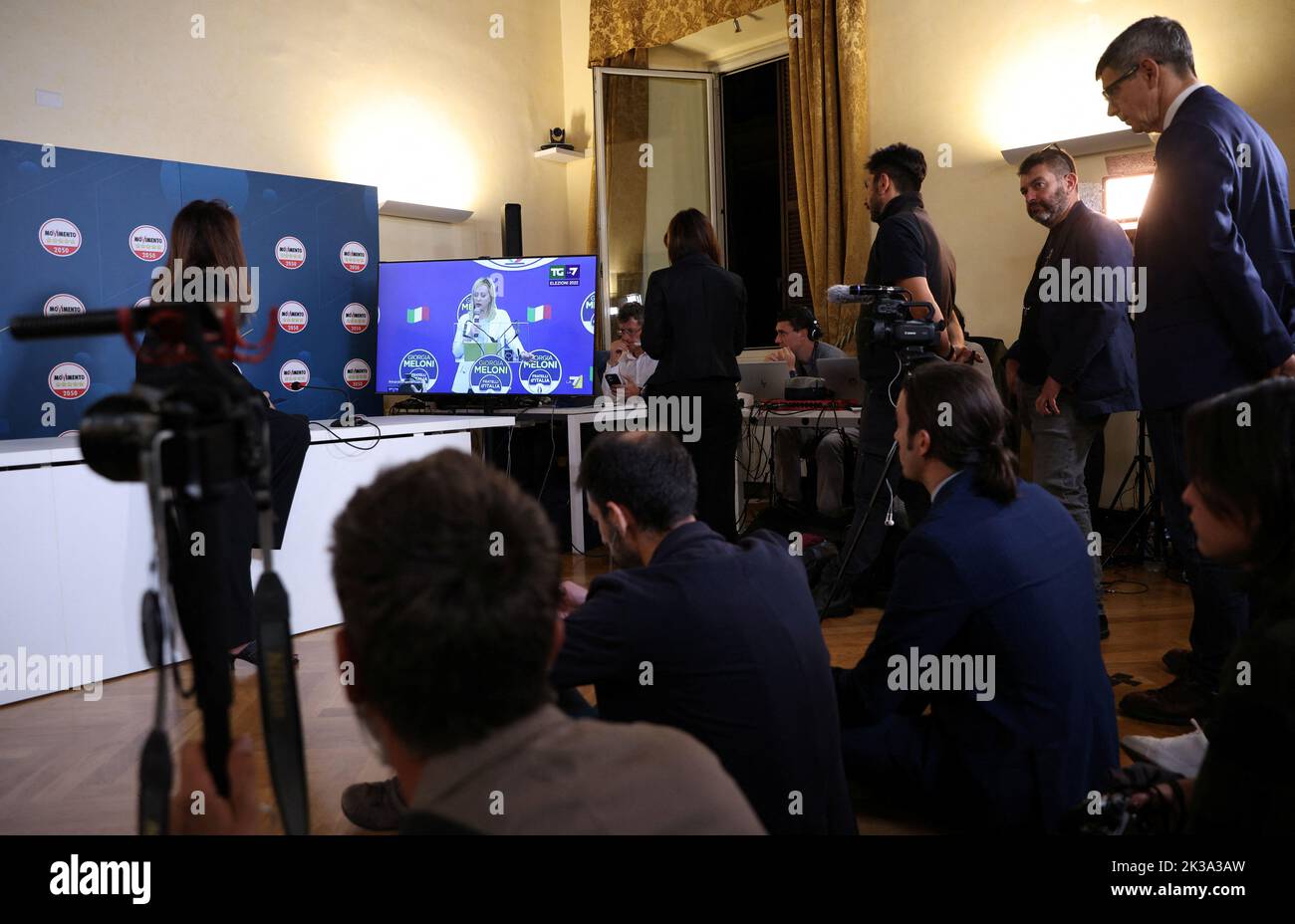 Les membres des médias regardent un écran de télévision avec le chef ...