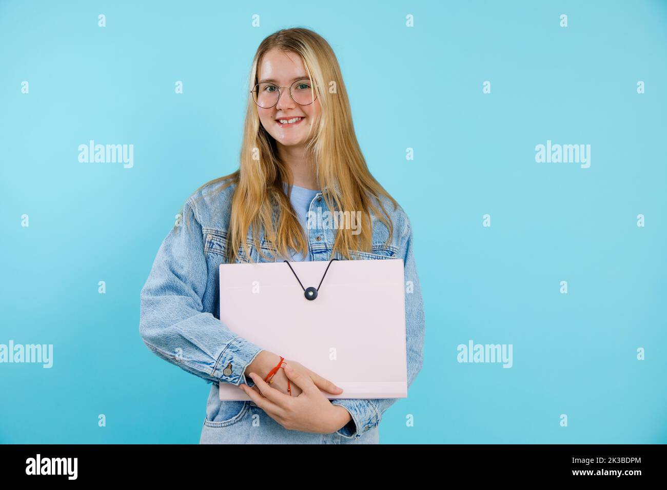 Portrait d'une jeune fille adolescente joyeuse tenant un grand dossier ...