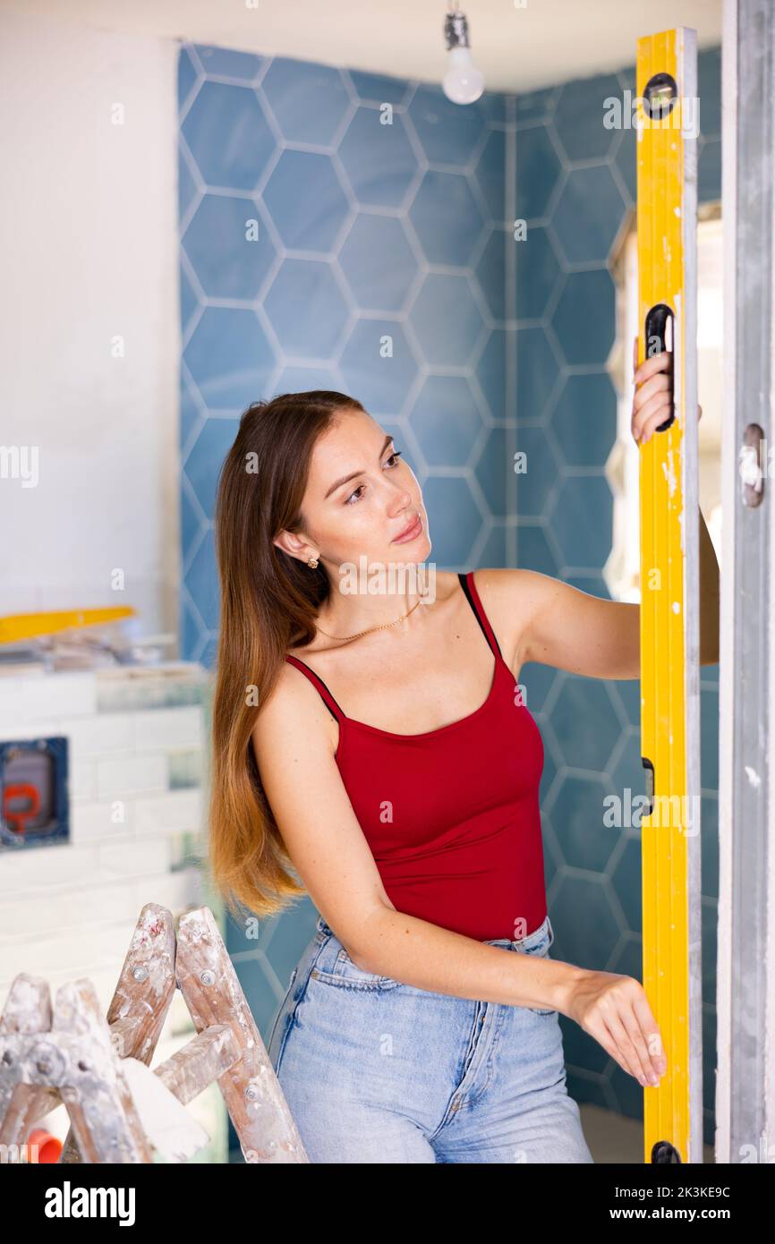 La femme mesure les écarts par rapport au mur vertical prédéterminé à l ...