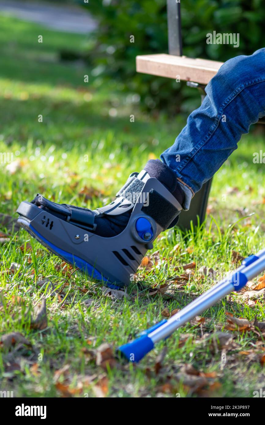 Un garçon avec un pied cassé et une chaussure orthopédique ou un ...