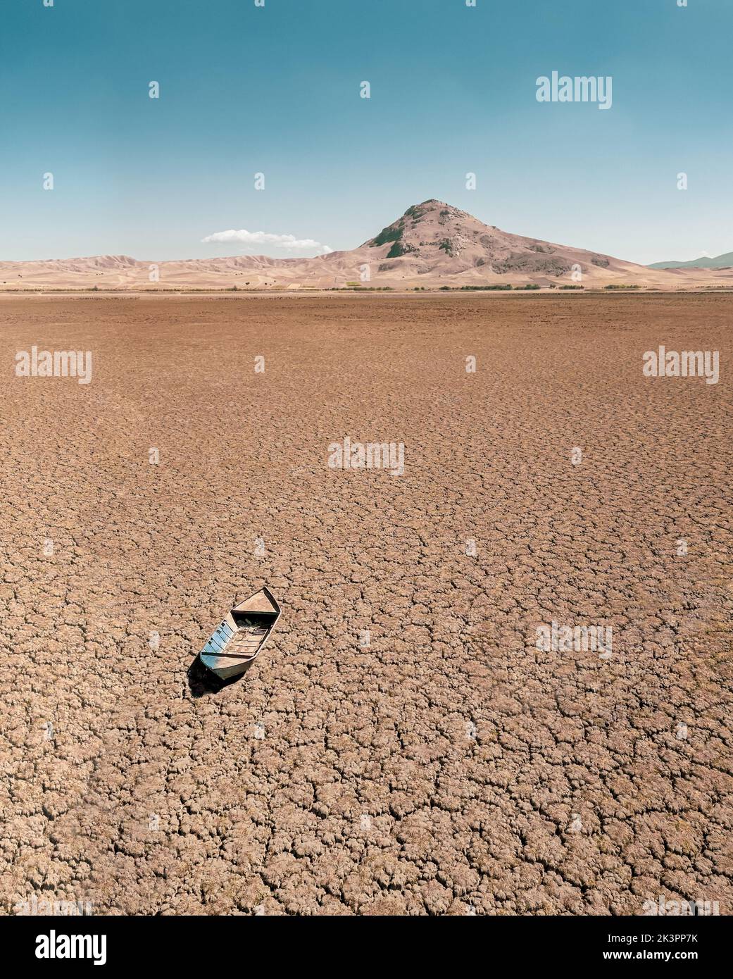Bateau à rames abandonné sur un sol fissuré sur un lit de lac séché en ...