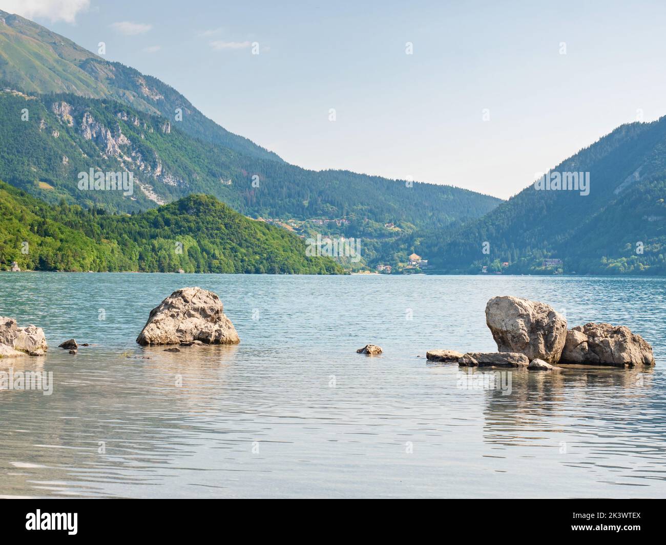Pierres empilées sur les rives de l'eau bleu-vert du lac de montagne ...
