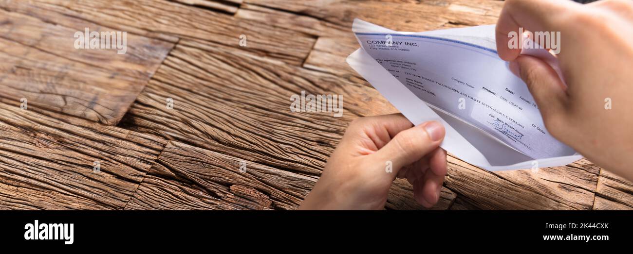 Chèque ou chèque de paie en main. Salaires et traitements Photo Stock ...