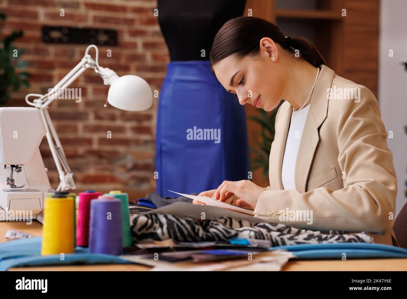 Une jeune fille est une designer de mode, dessine un croquis sur le ...