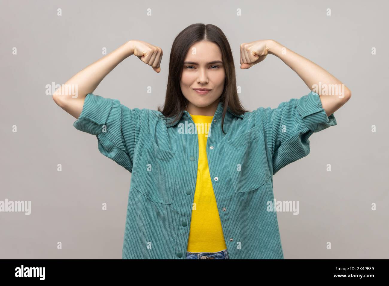 Je suis fort et indépendant. Fière confiante femme montrant le biceps ...