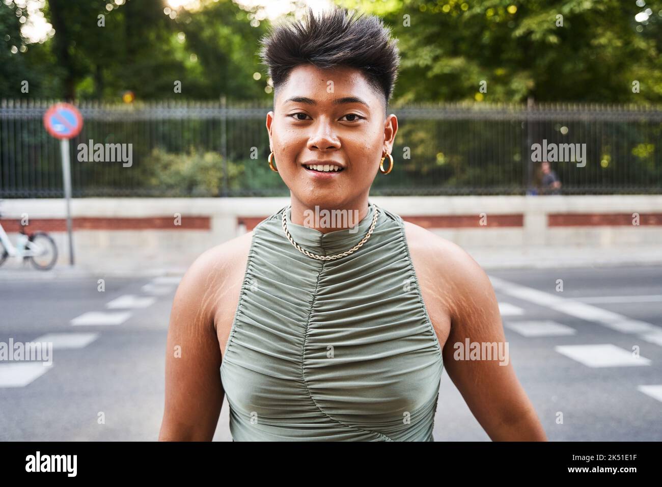 Gaie femme transgenre asiatique avec des cheveux courts et des boutons ...