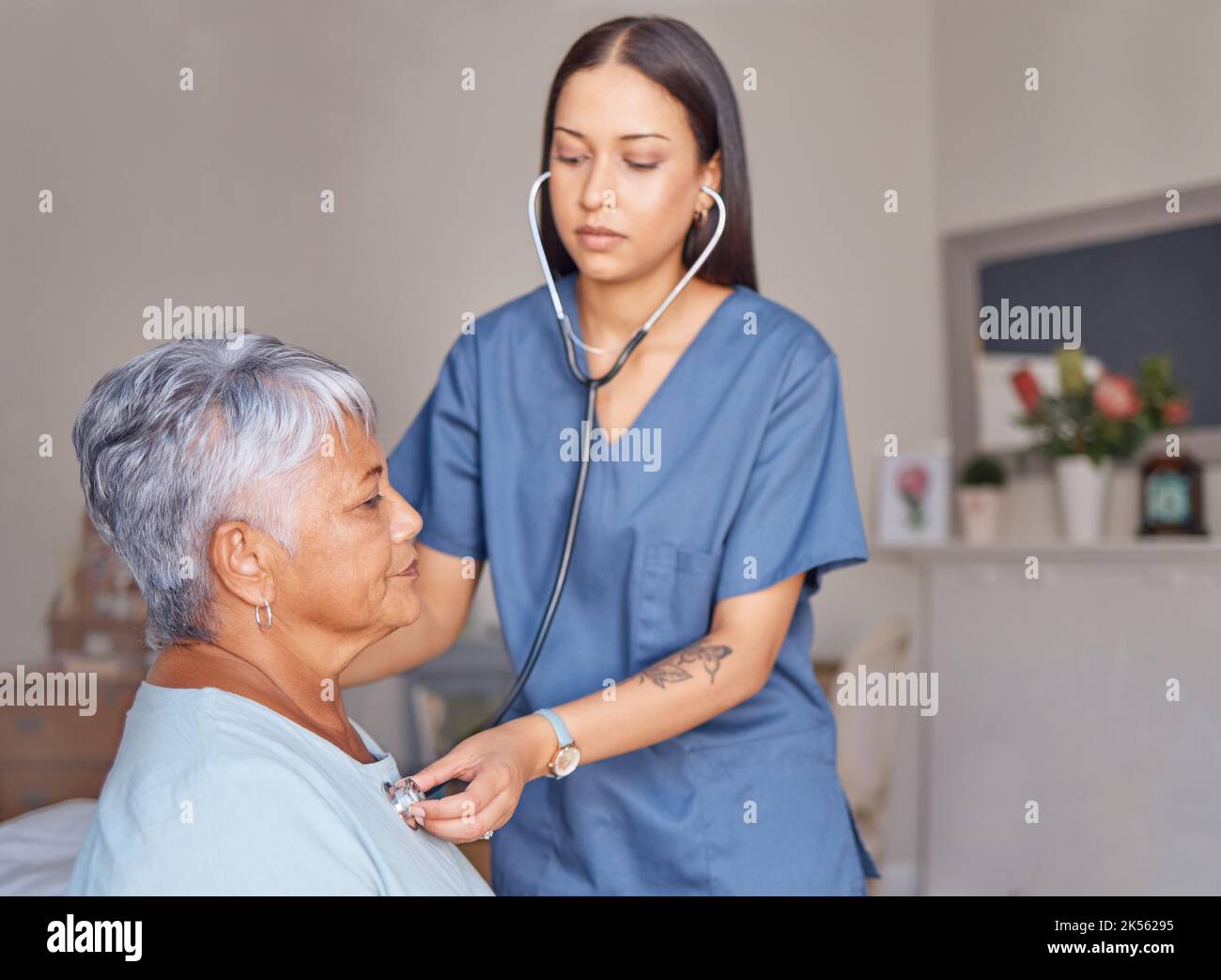 Patient âgé, infirmière et infirmier avec un stéthoscope à l'écoute du ...