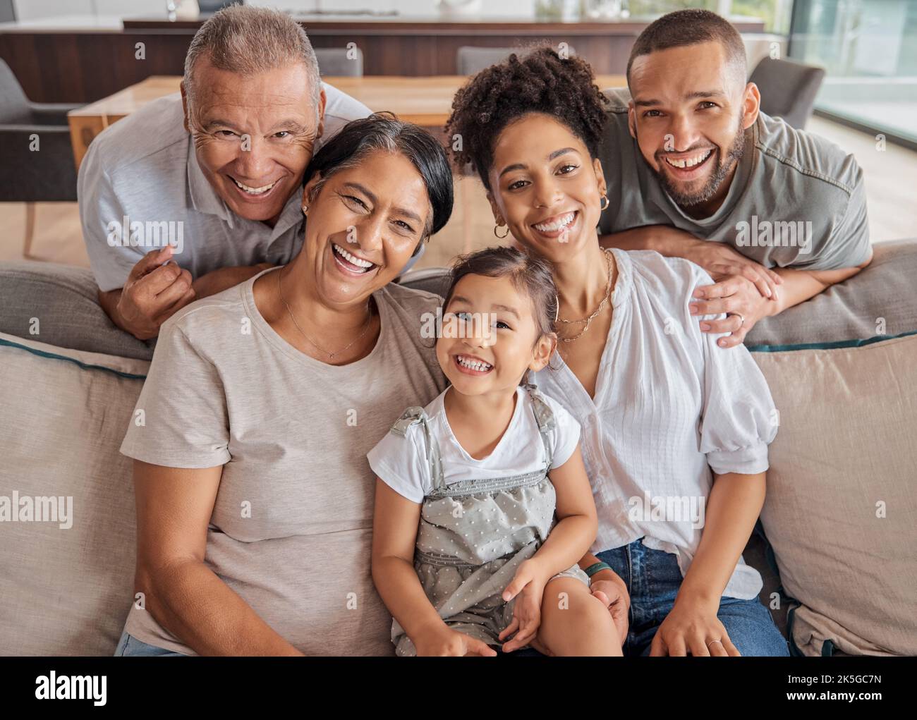 Famille heureuse de couple, grands-parents et enfant sur le canapé dans ...