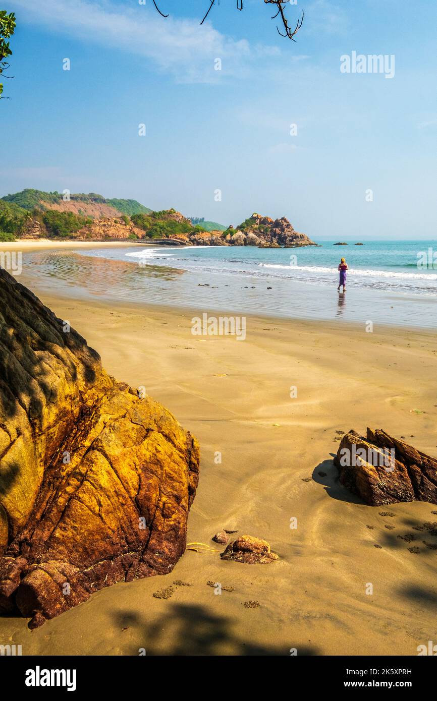 Touriste féminin sur une plage vide au milieu de magnifiques paysages ...