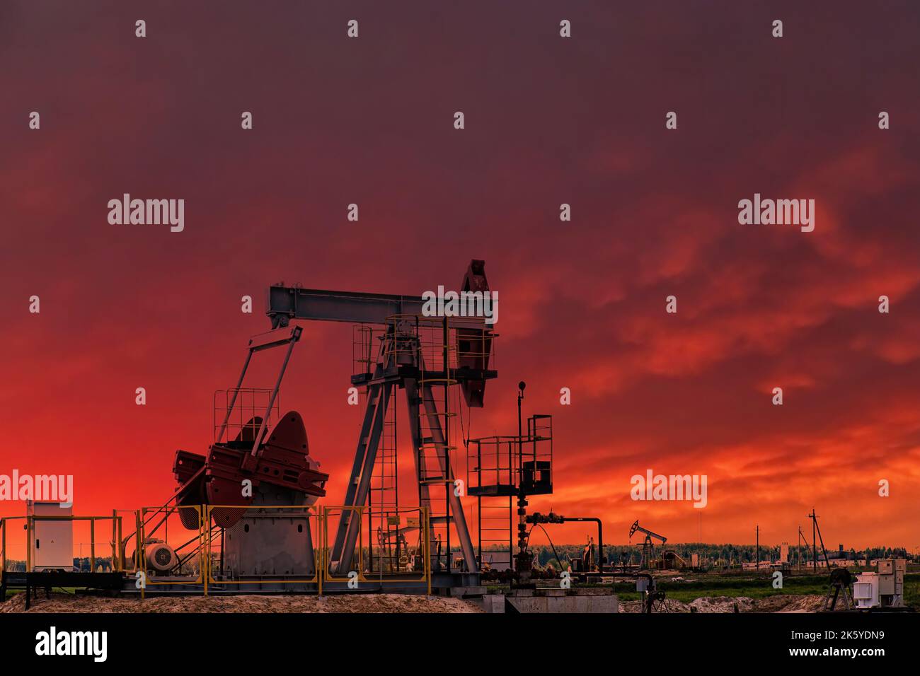 Engin de forage pétrolier et cric à pompe sur fond de coucher de soleil ...