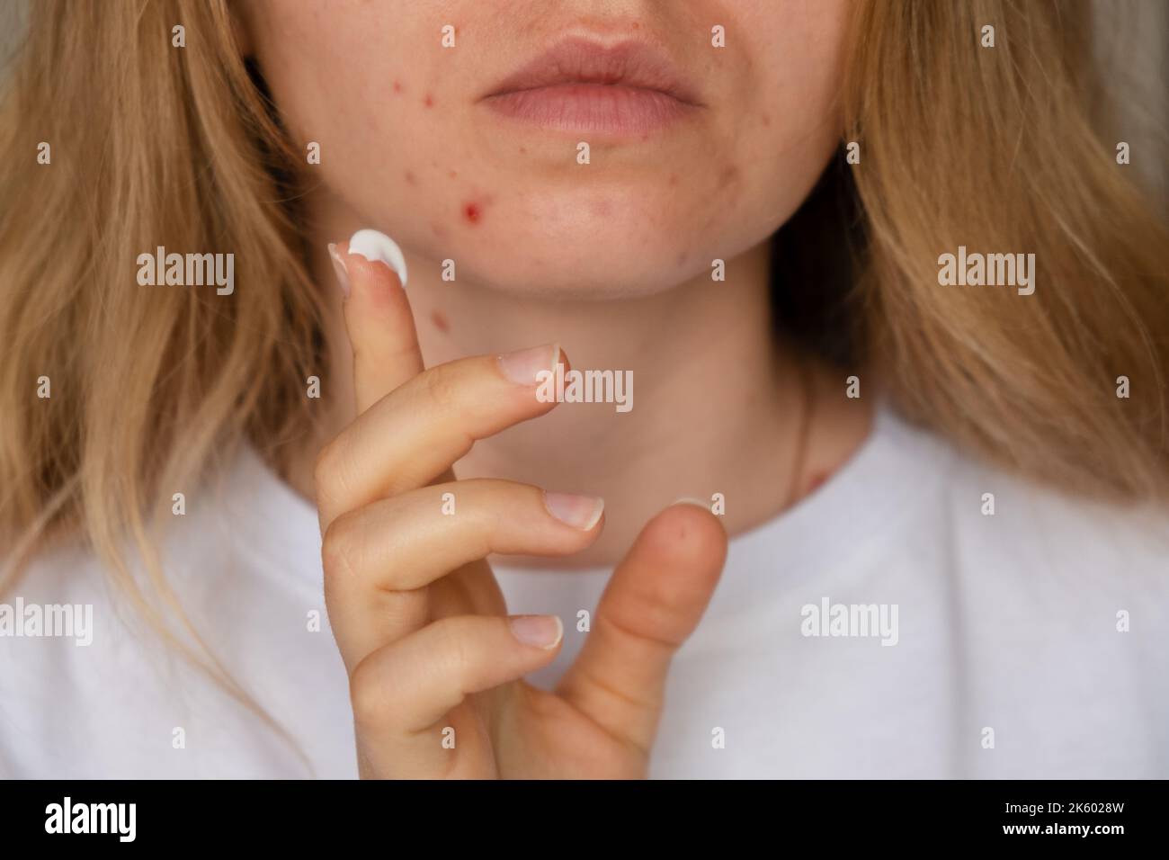 La femme méconnaissable applique le maquillage, le traitement de sérum ...