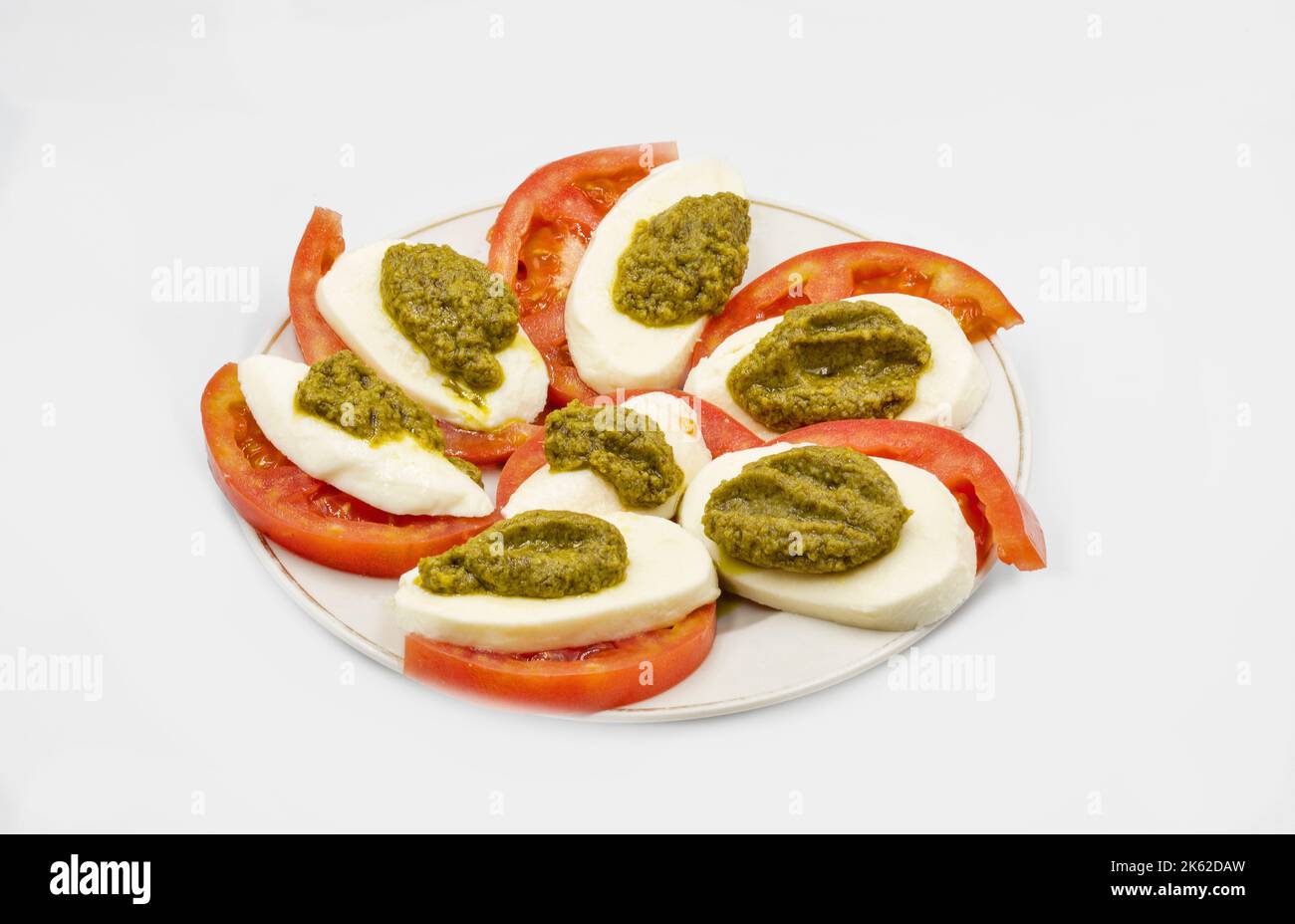 Mozzarella avec tomates et pesto gros plan sur blanc. Salade Caprese ...