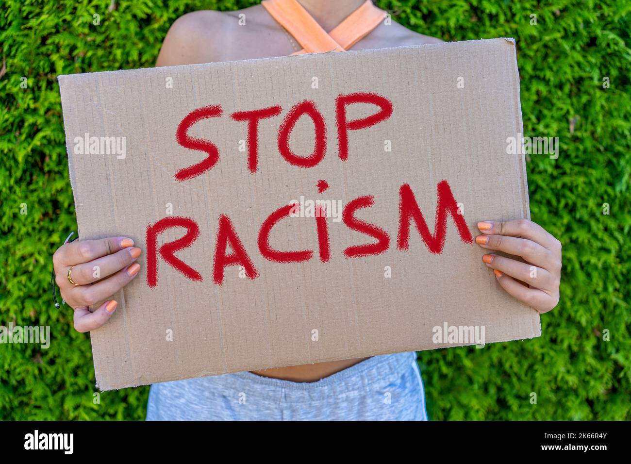 Femme tenant une pancarte contre le racisme Banque de photographies et ...