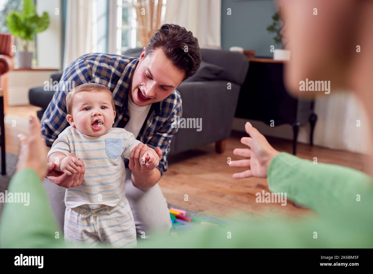 Famille transgenre encourager bébé à faire les premiers pas dans le ...
