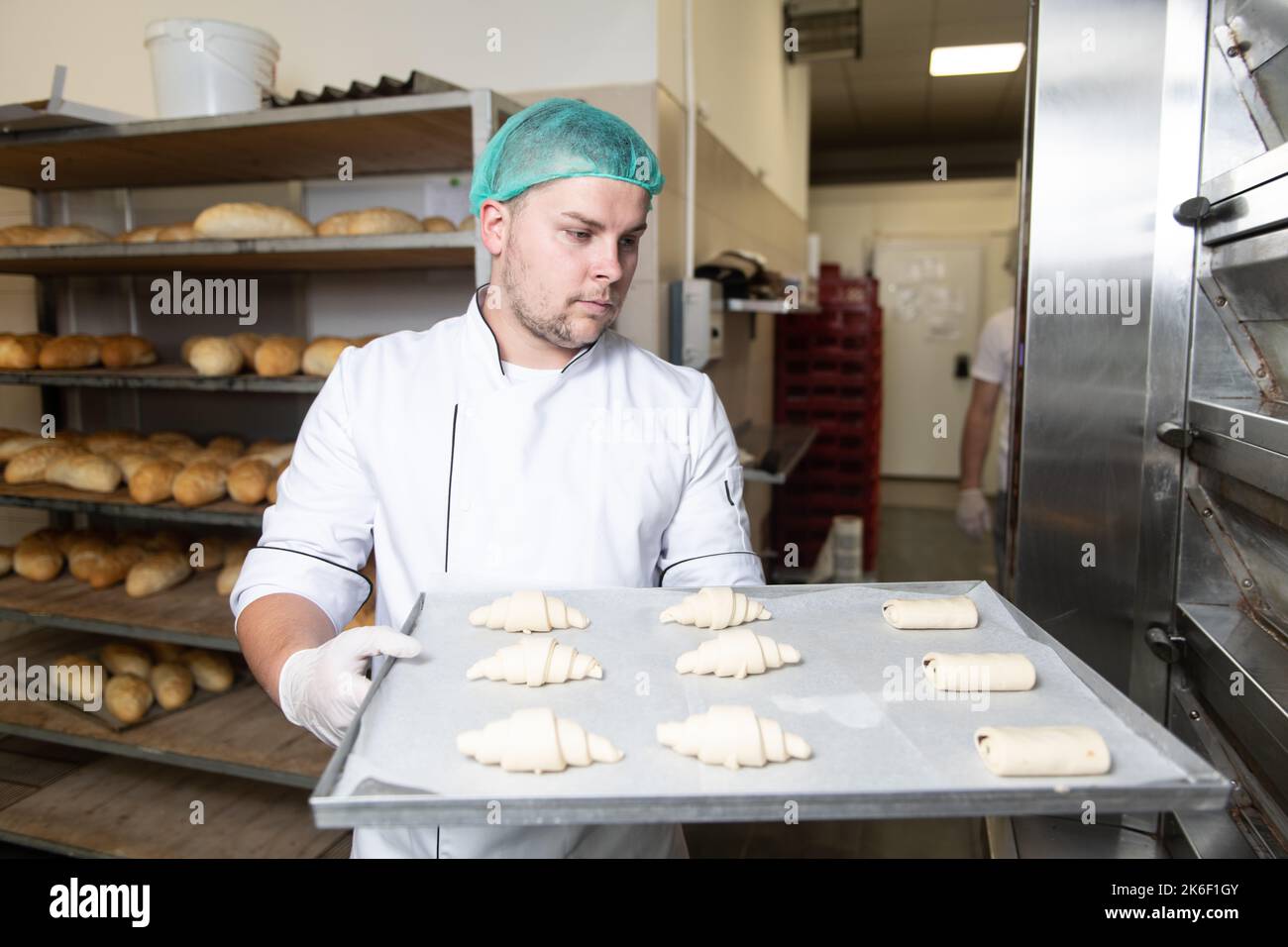 Un jeune chef pâtissier fait un peu de croissant dans le processus de ...