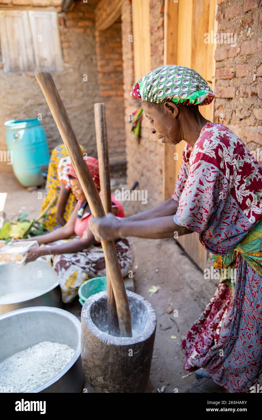 Une femme africaine utilise un gros mortier et un pilon en bois pour ...