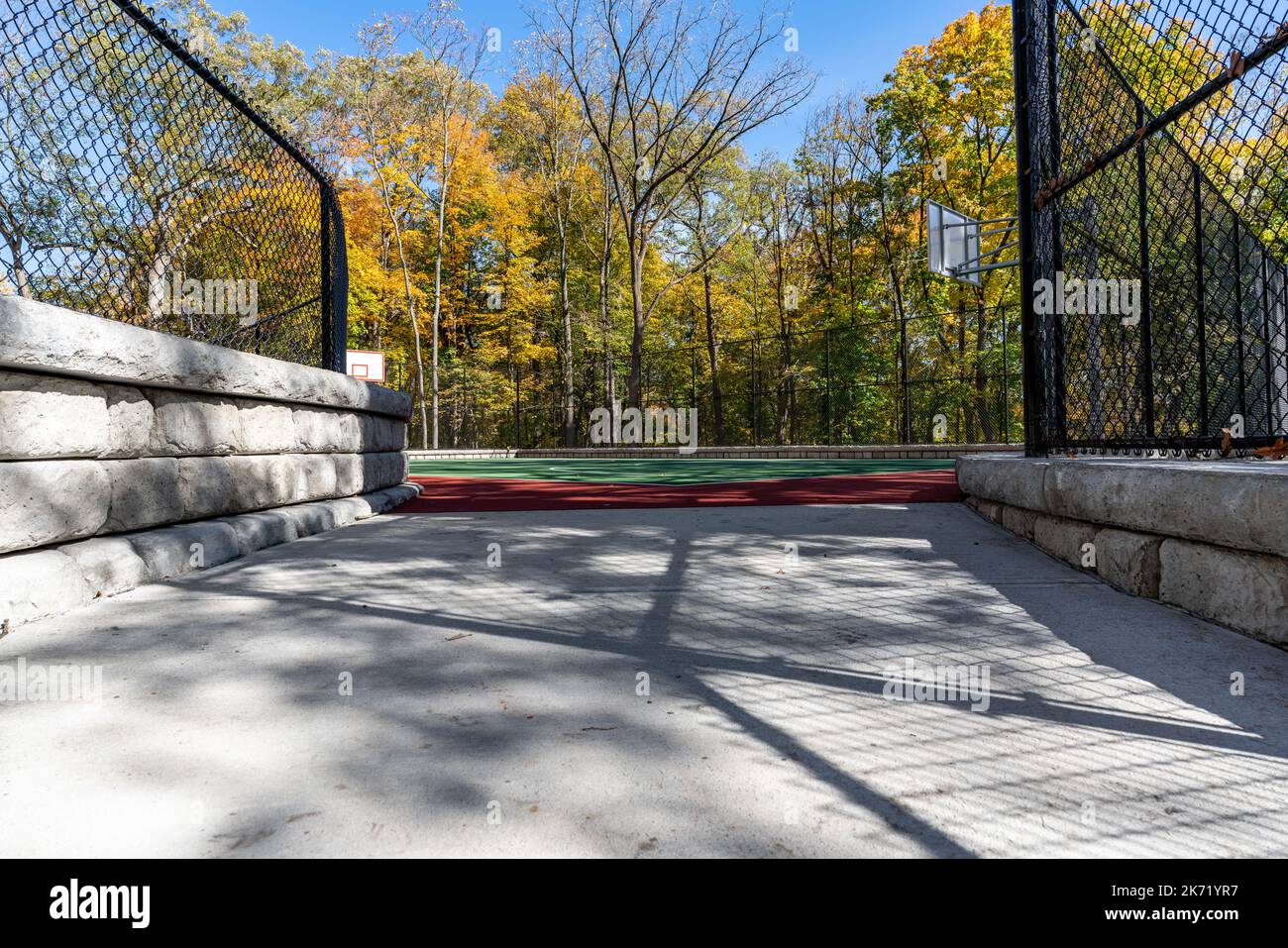 trottoir en béton avec mur de soutènement et terrain de basket-ball ...