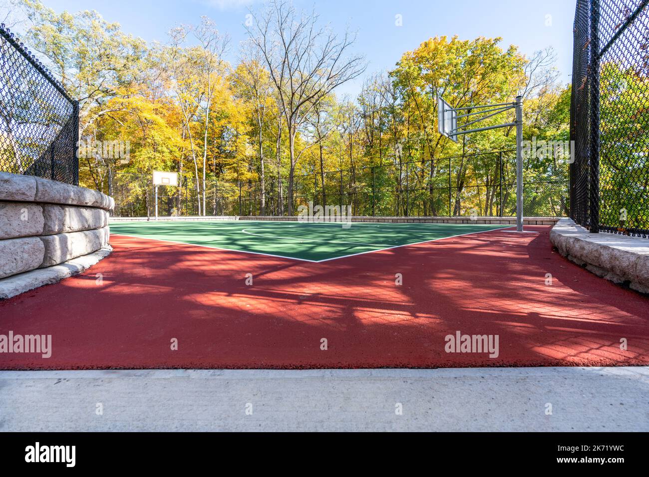 trottoir en béton avec mur de soutènement et terrain de basket-ball ...