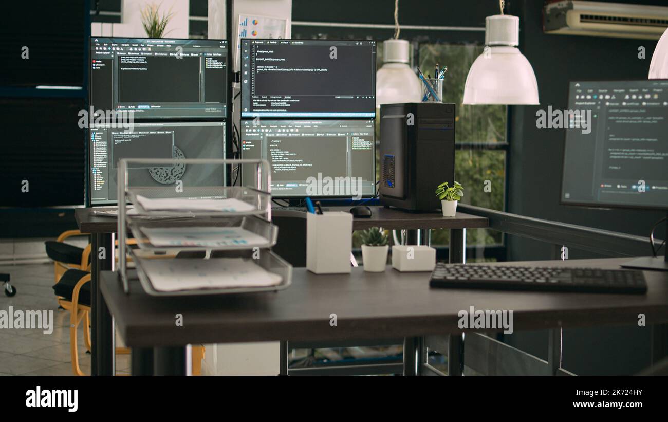 Moniteurs informatiques affichant le code d'analyse dans un bureau d'agence informatique vide ...