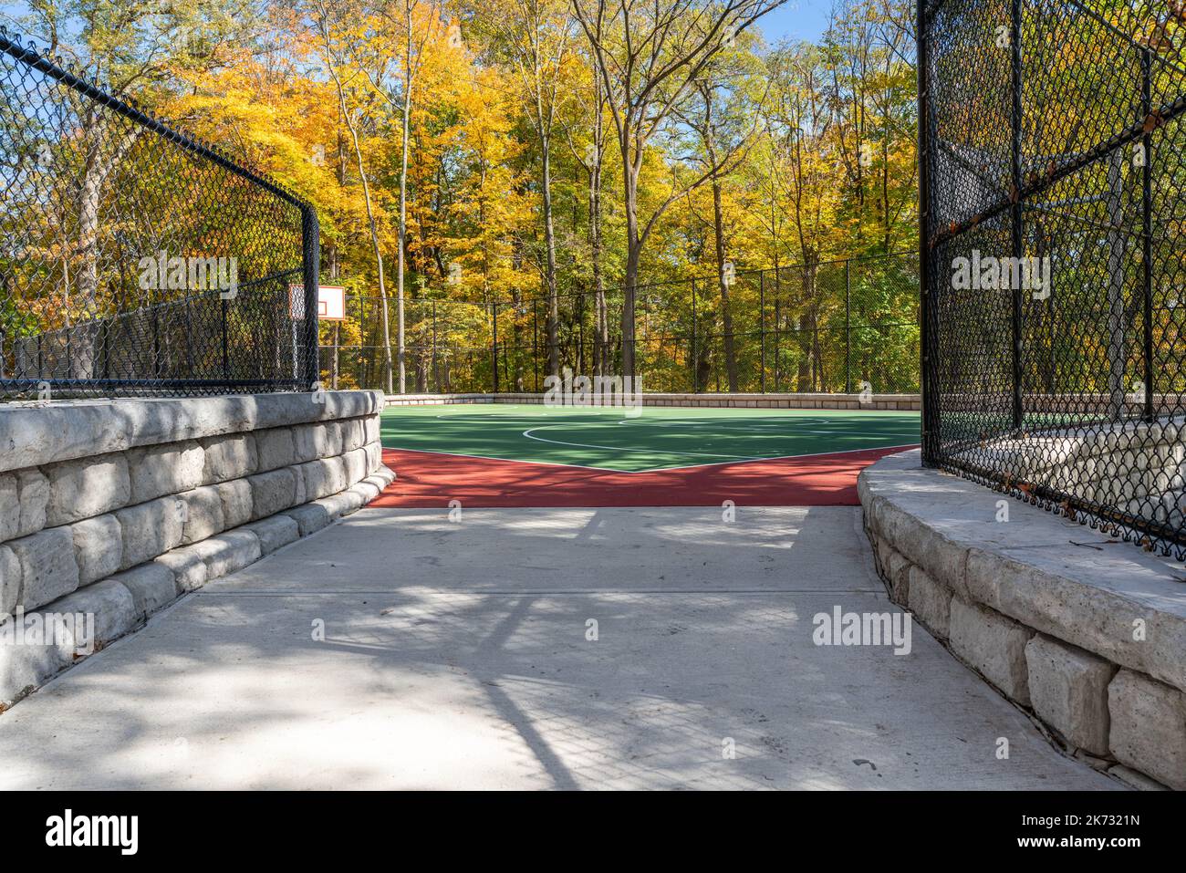 trottoir en béton avec mur de soutènement et terrain de basket-ball ...