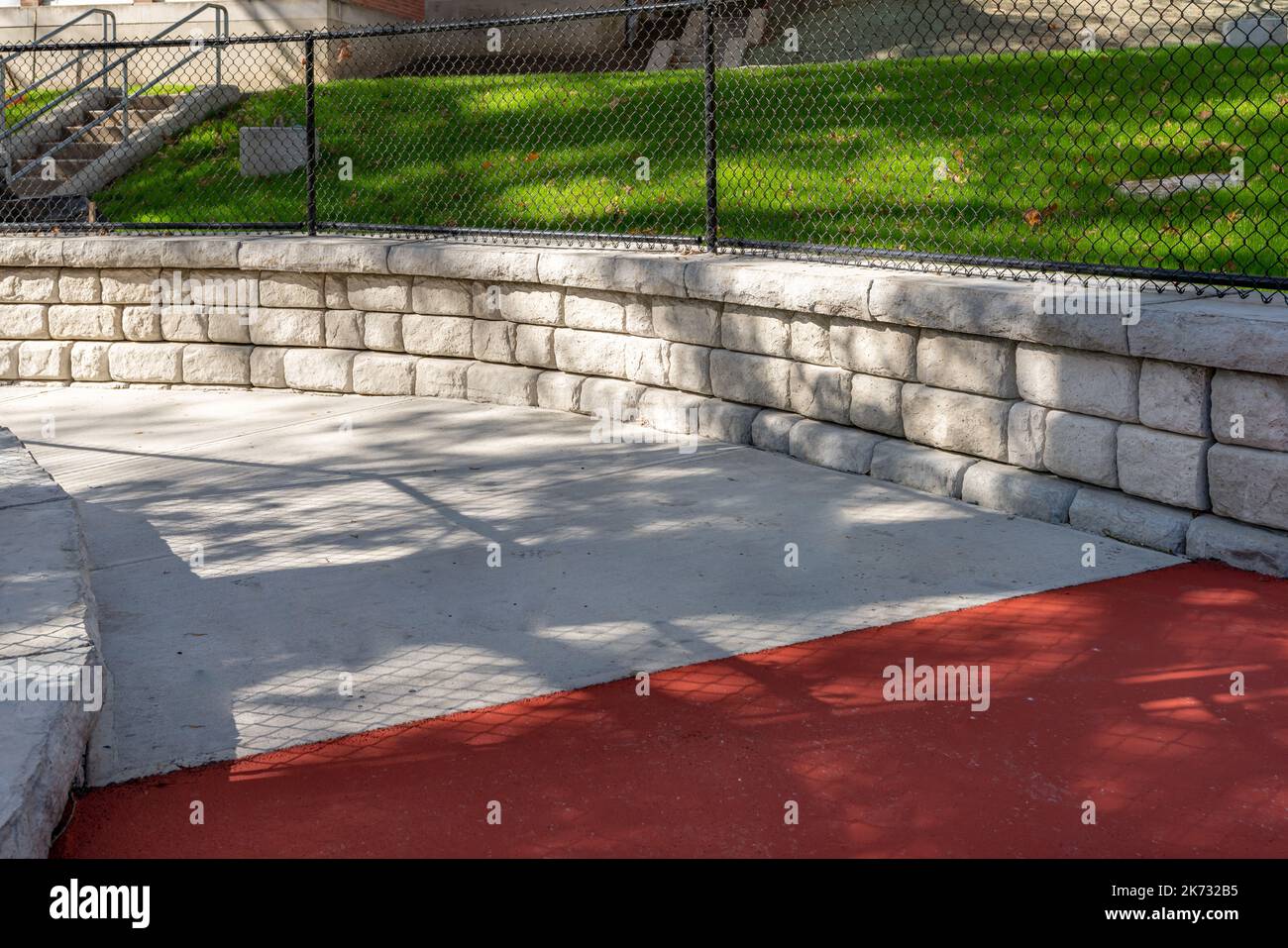 trottoir en béton avec mur de soutènement et terrain de basket-ball ...