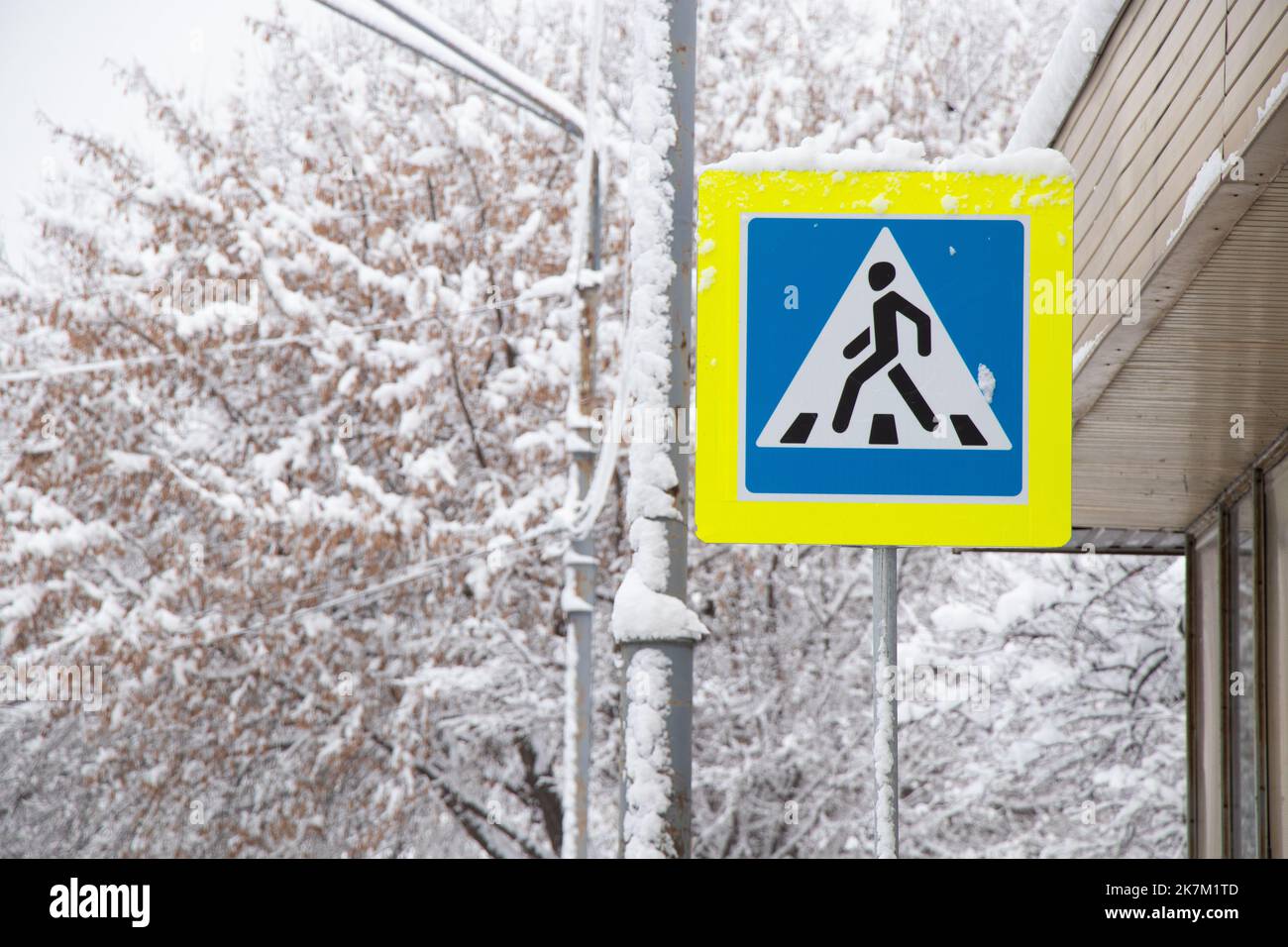Un signe de passage piéton en hiver dans la neige dans la ville a ...
