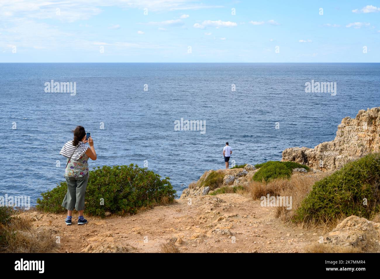 Une femme prenant une photo de téléphone de son fils debout sur une ...