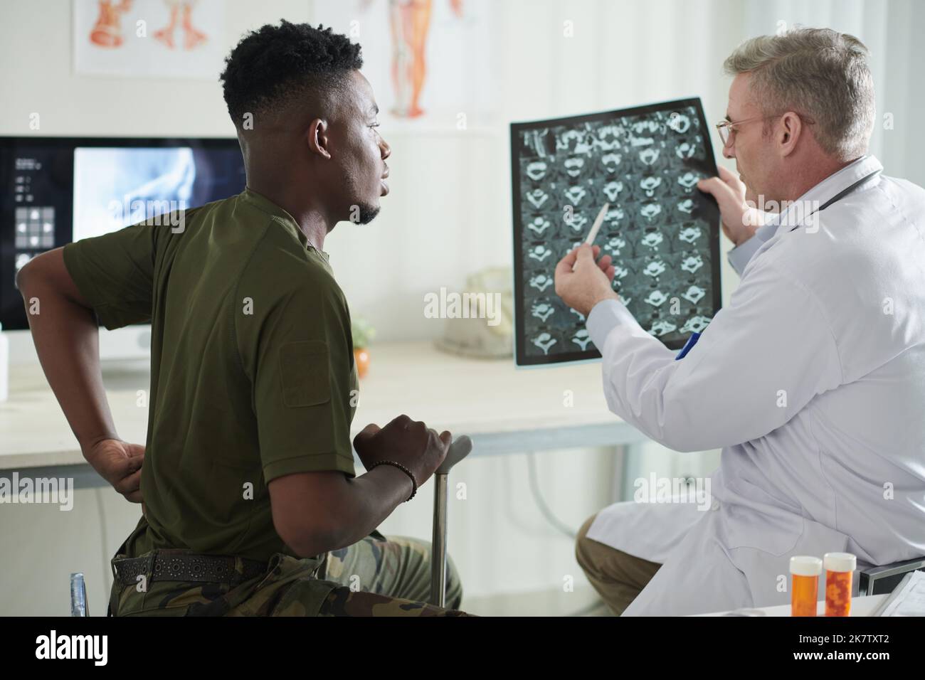 Médecin parlant à l'homme militaire au sujet de la douleur de dos et ...