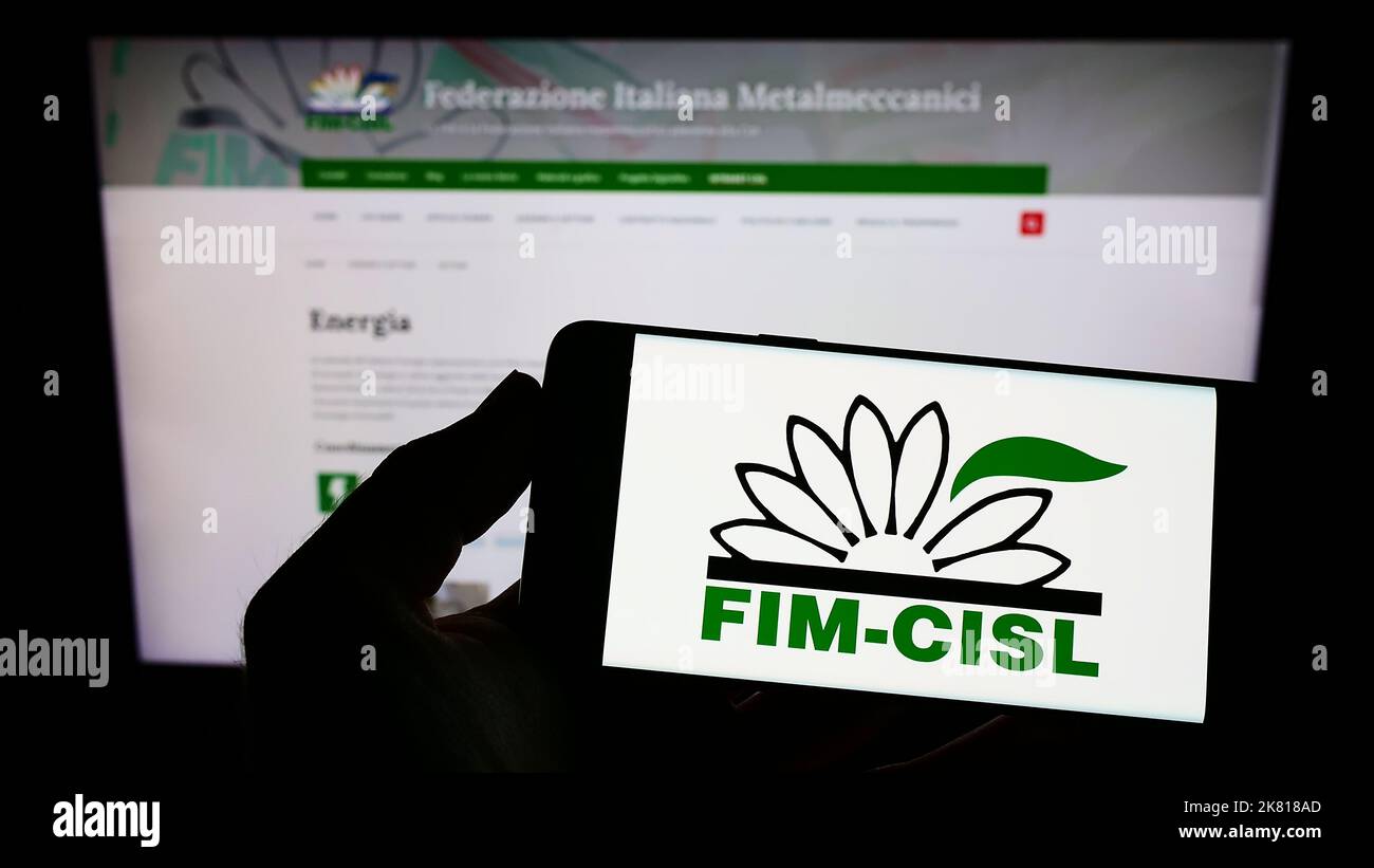 Personne tenant un smartphone avec le logo du syndicat italien FIM-CISL ... Personne tenant un smartphone avec le logo du syndicat italien FIM-CISL ...
