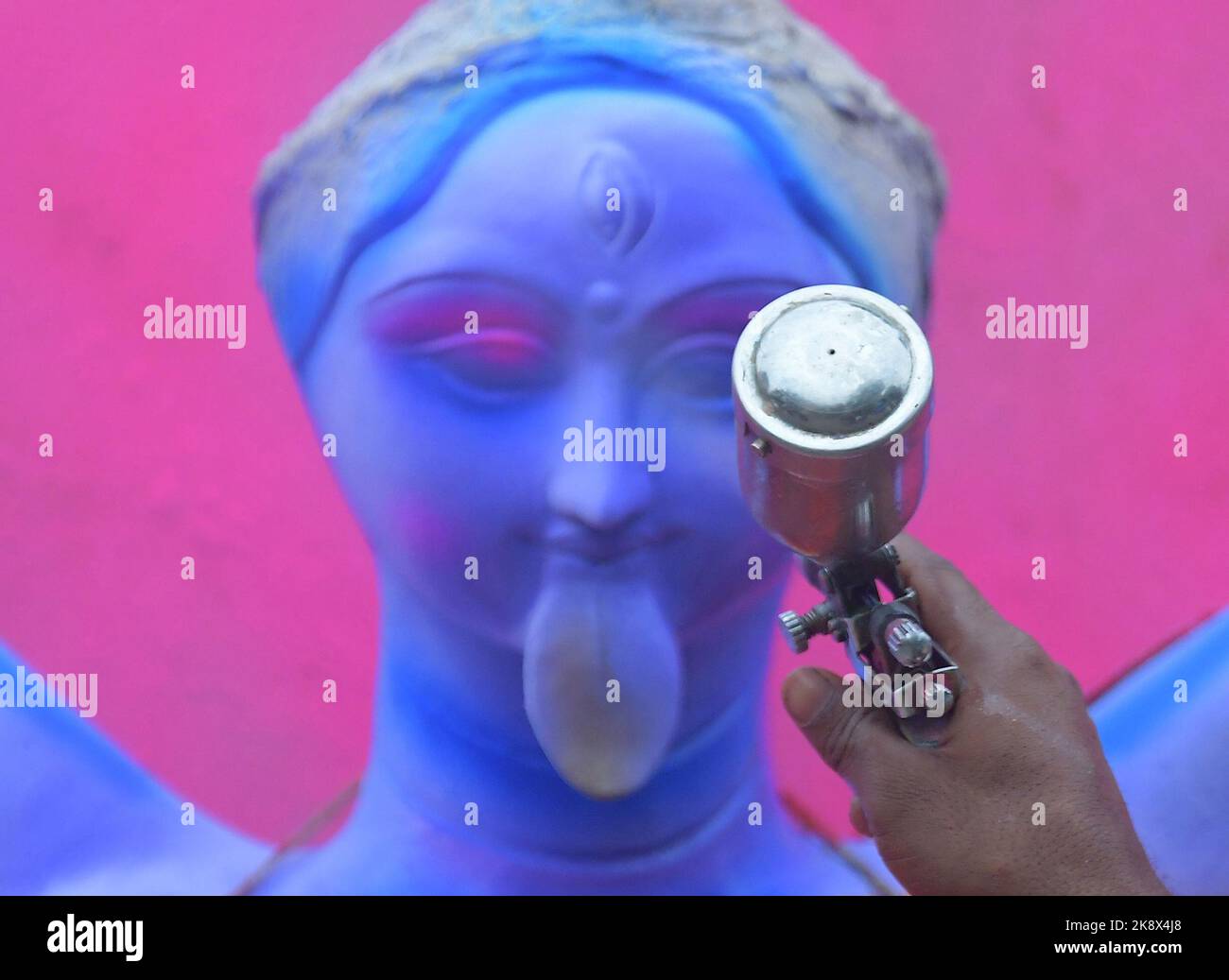 Un artisan qui fait la touche finale à un idole d'argile semi-fini de la déesse hindoue Kali ...