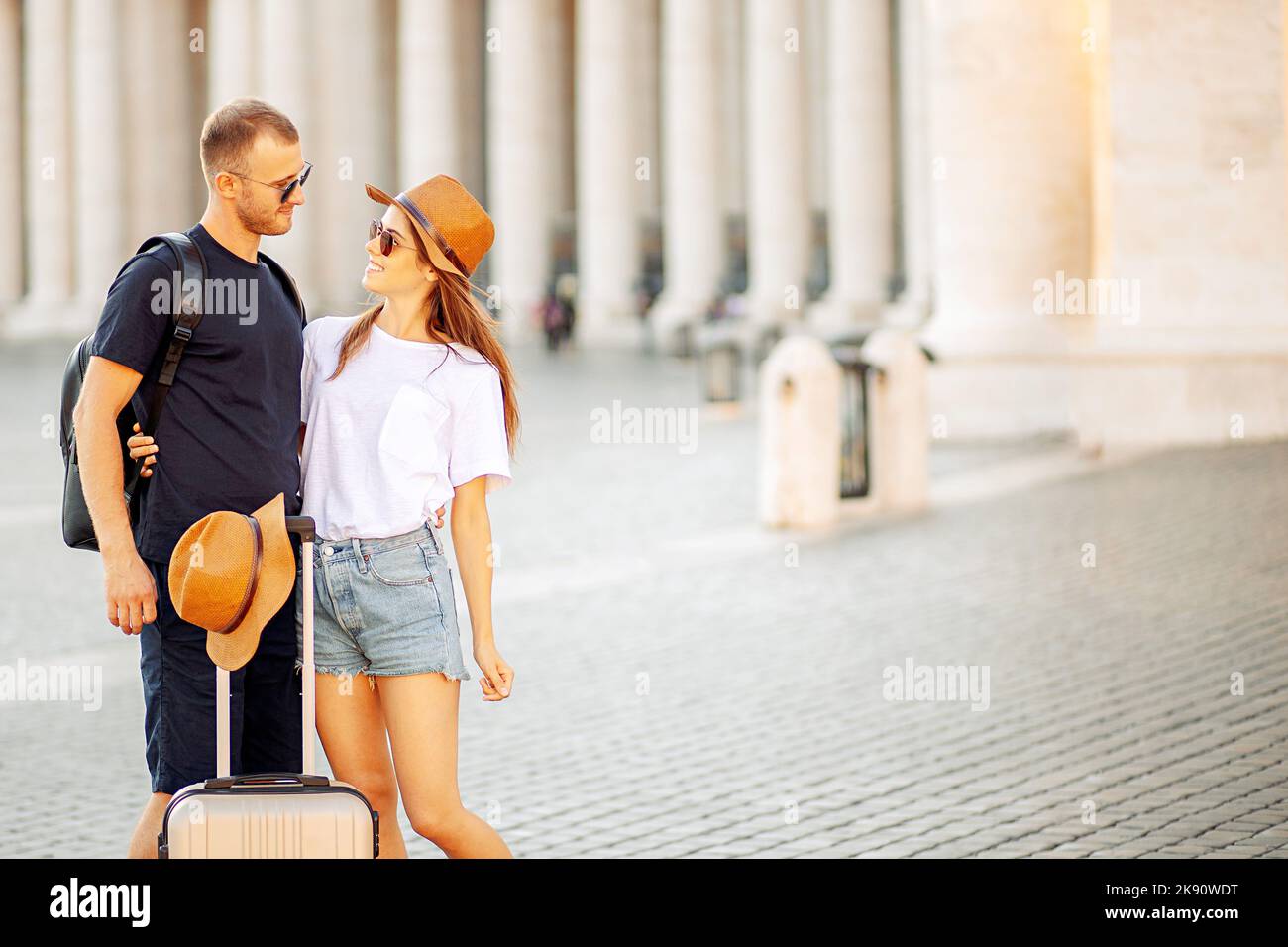 Un jeune couple de voyageurs qui s'embrasse dans la ville et qui ...