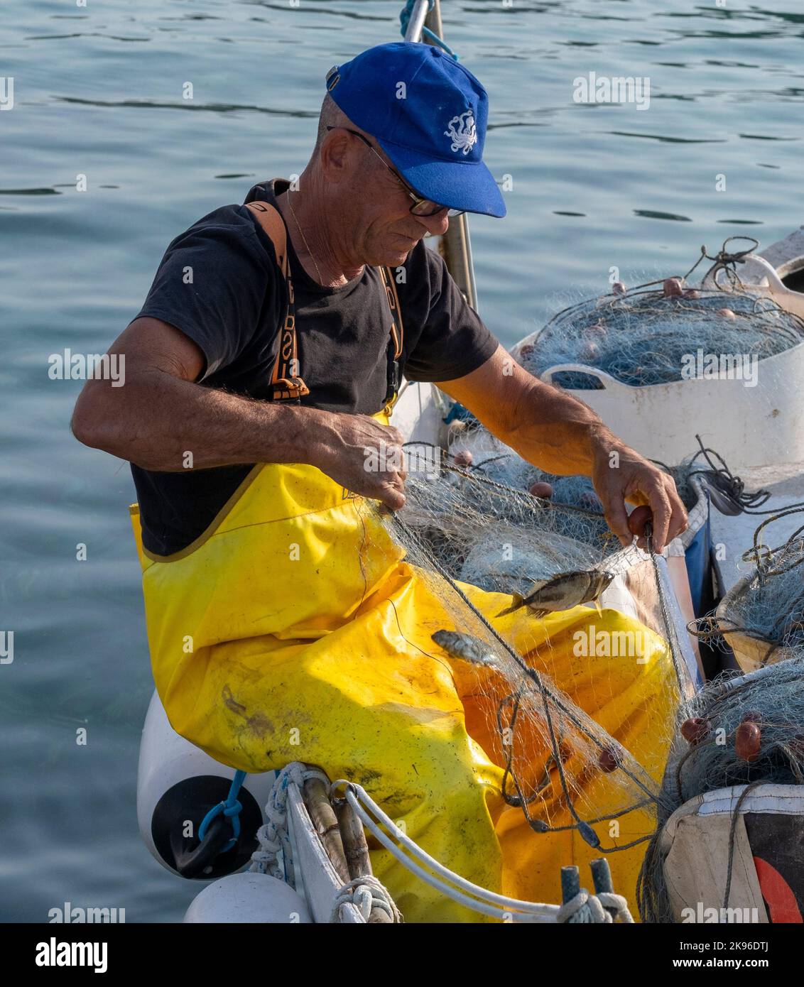 Pêcheur avec sa prise de poisson en bateau de pêche traditionnel Banque ...