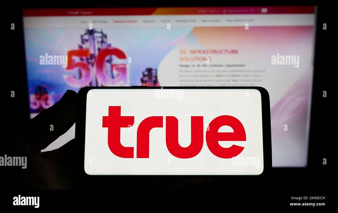 Personne tenant un smartphone avec le logo de la société thaïlandaise ... Personne tenant un smartphone avec le logo de la société thaïlandaise ...