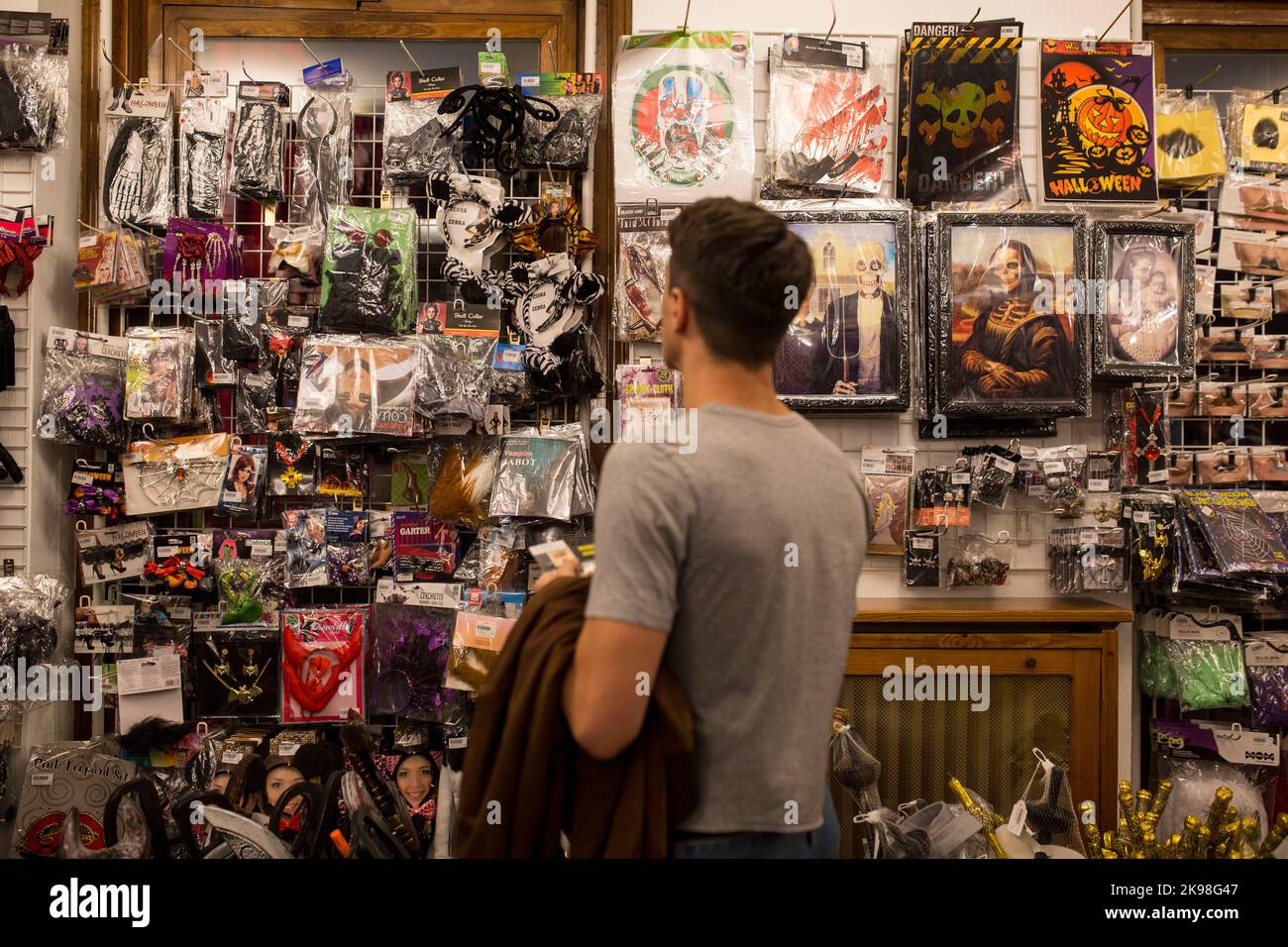 Un homme regarde les accessoires de costume à l'intérieur du magasin de ...