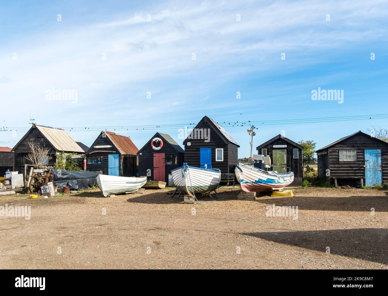 Trois bateaux en bois construits en clinker devant les cabanes de ...