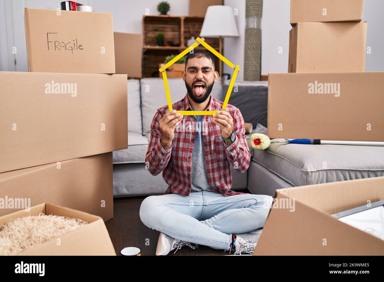 Homme du Moyen-Orient avec barbe assis sur le sol à la nouvelle maison ...
