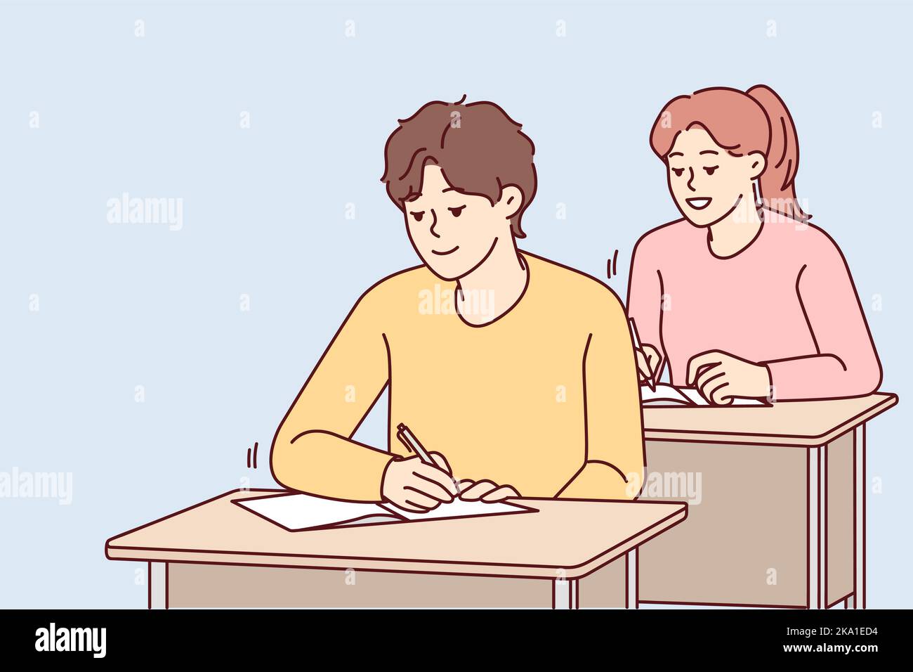 Des élèves souriants s'assoient au bureau pour écrire dans des carnets ...